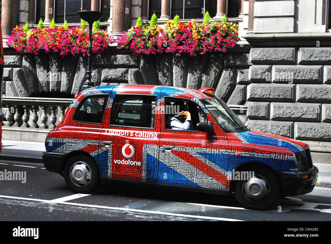 London taxi with Union Jack type advertising livery passes the Ale and ...