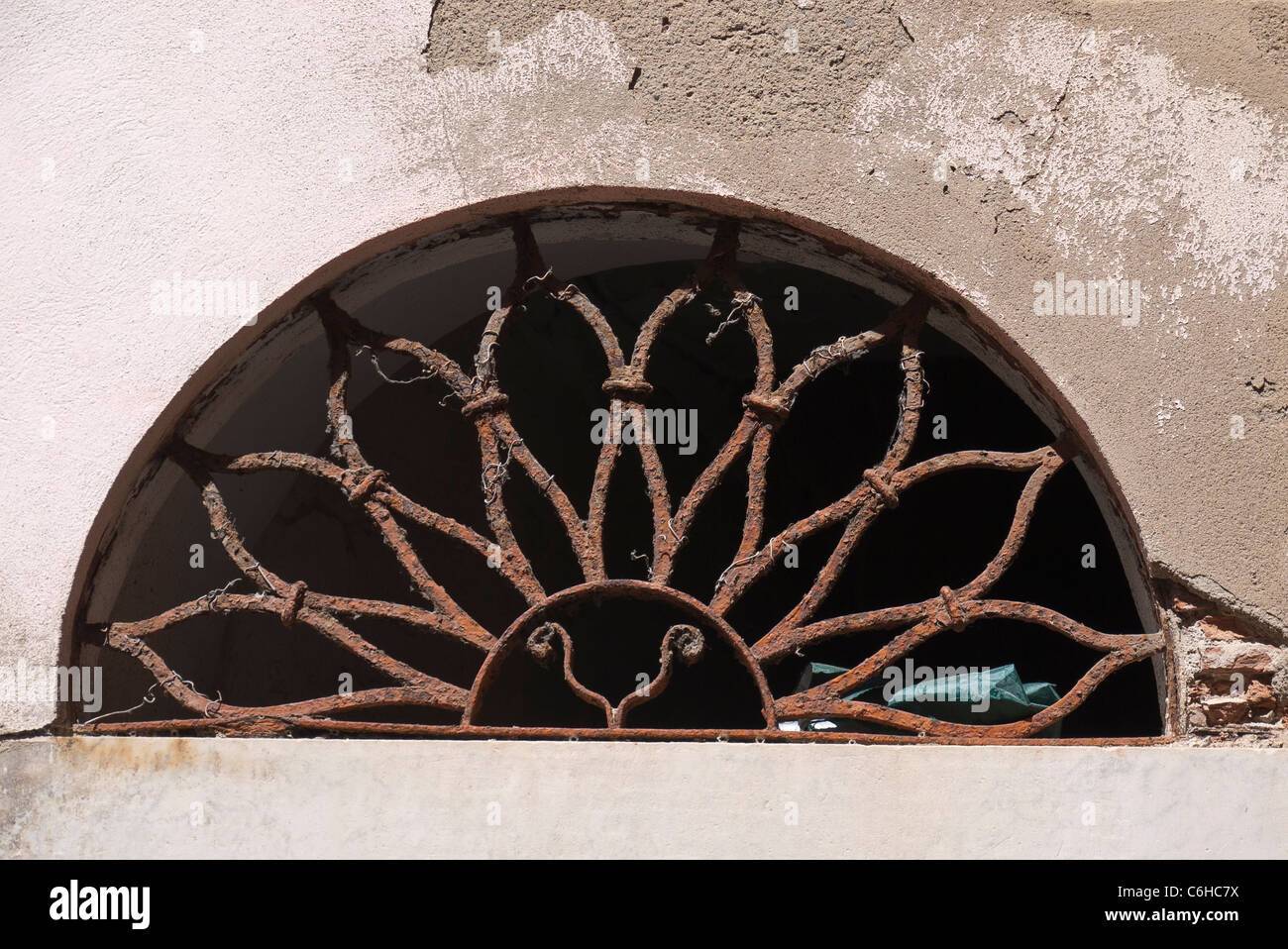 A decorative and rusted wrought iron transom enclosed in the shape of a ...