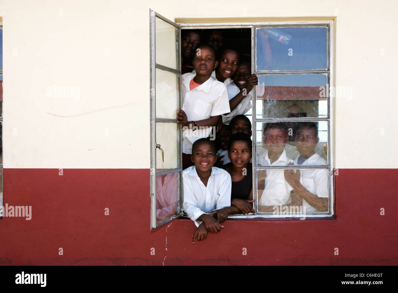 Group of school children leaning out through a classroom window Stock ...