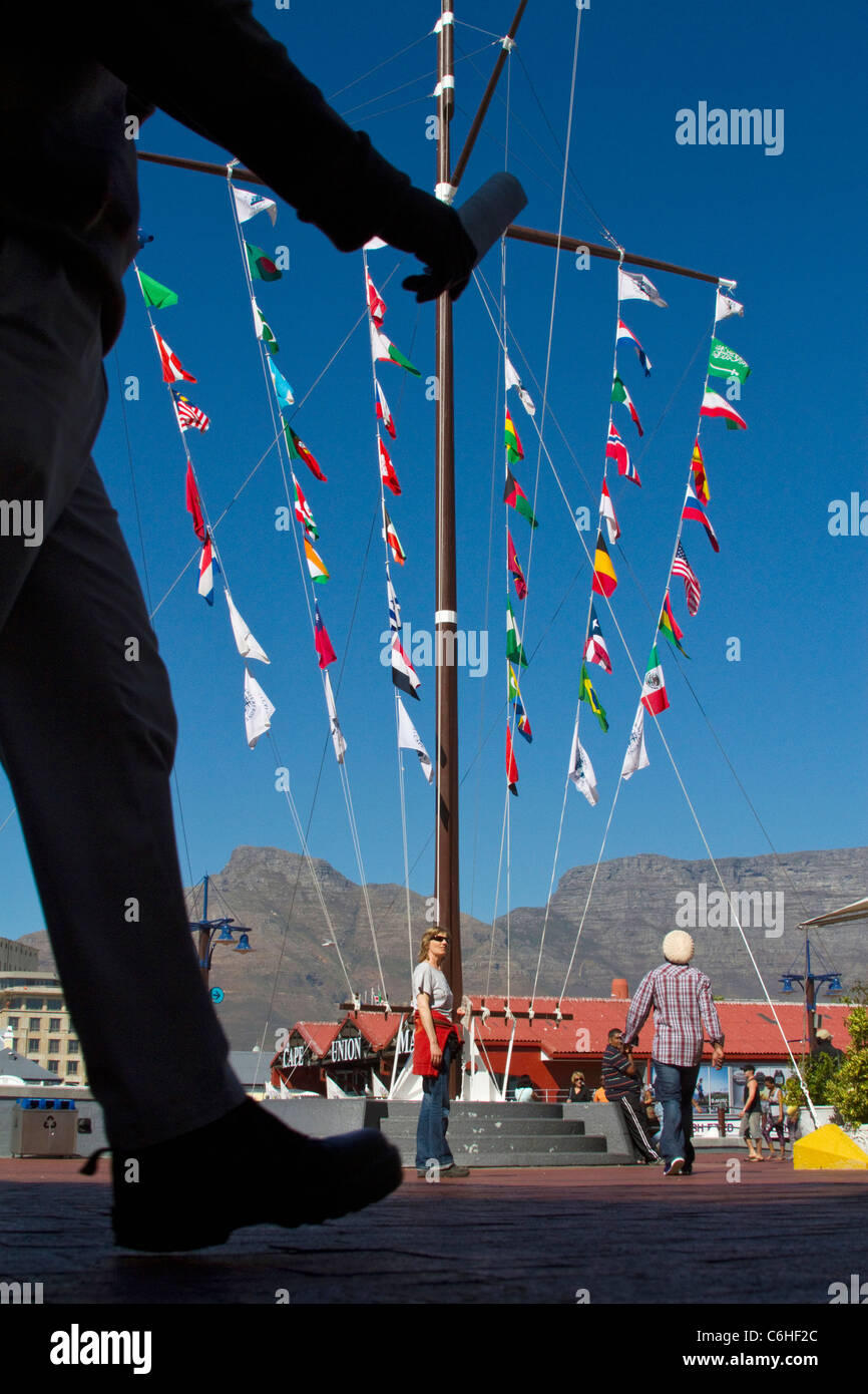 A person strides purposefully against a backdrop of flags on a tall ...