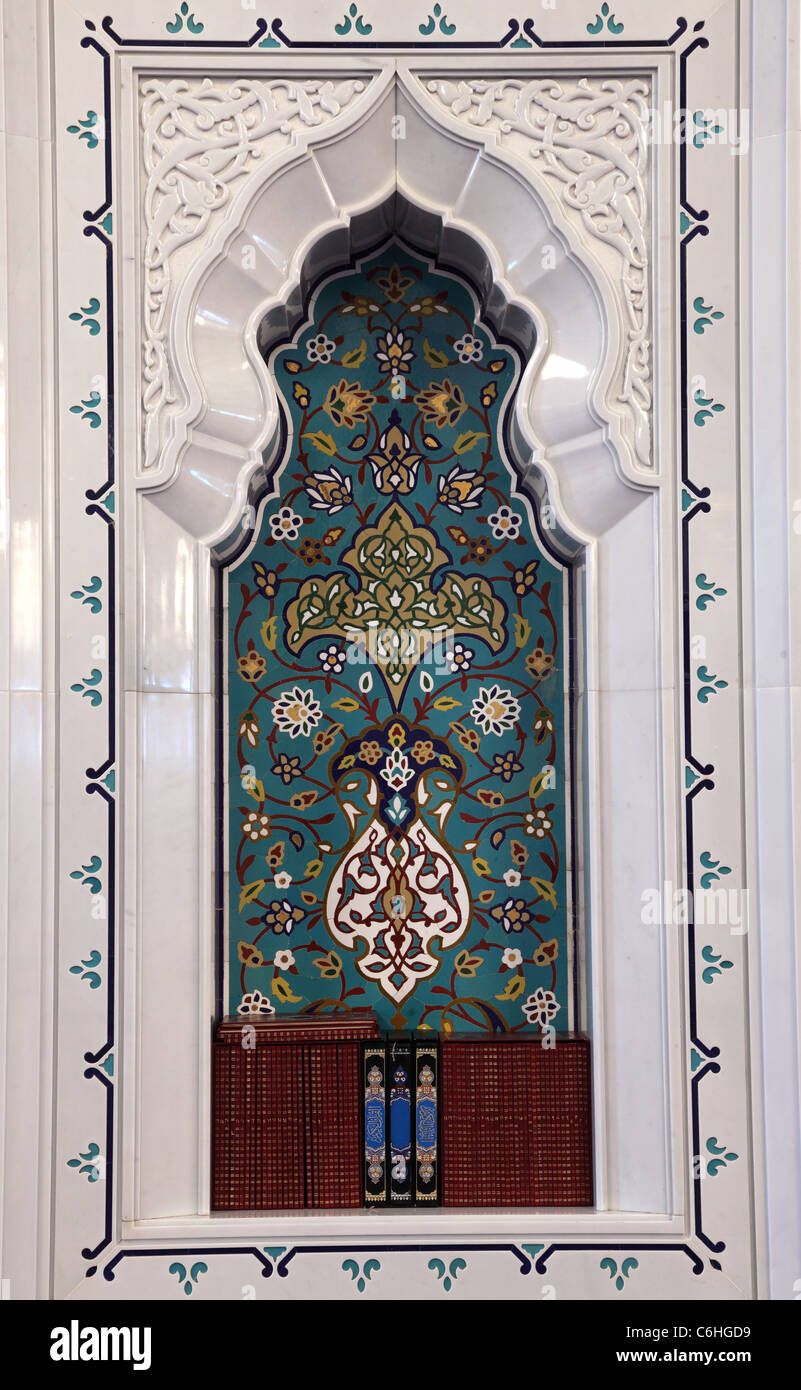 Oriental mosaic decoration in a mosque. Quran books in a shelf ...