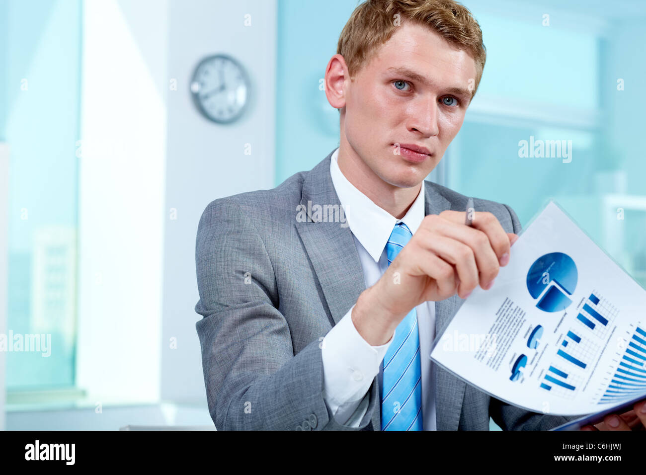 Portrait of a serious manager holding document Stock Photo - Alamy
