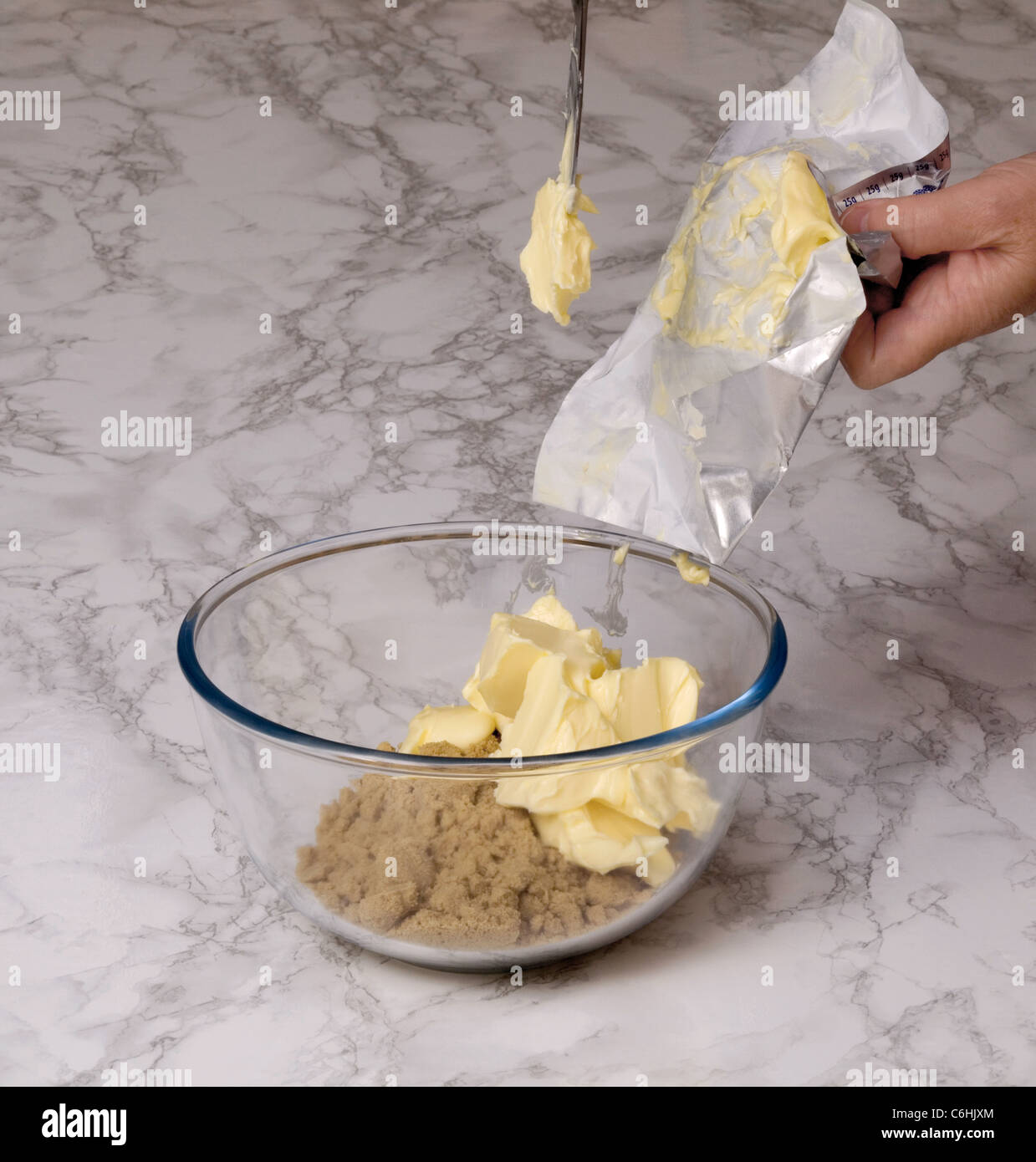 Butter being added to brown sugar in a mixing bowl, with space for text ...