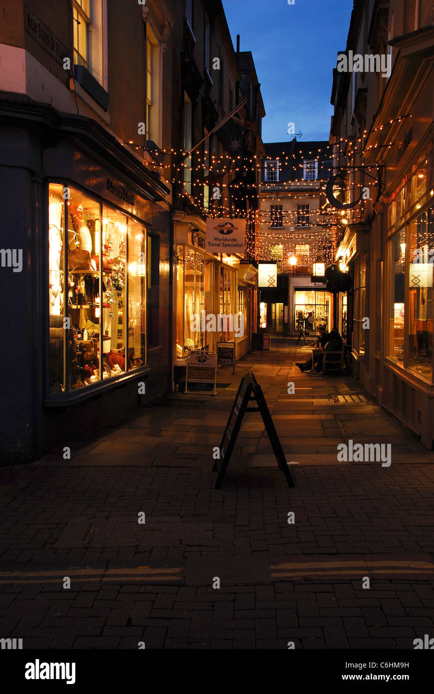 A quiet alley in the city of Bath with Christmas lights shining from ...