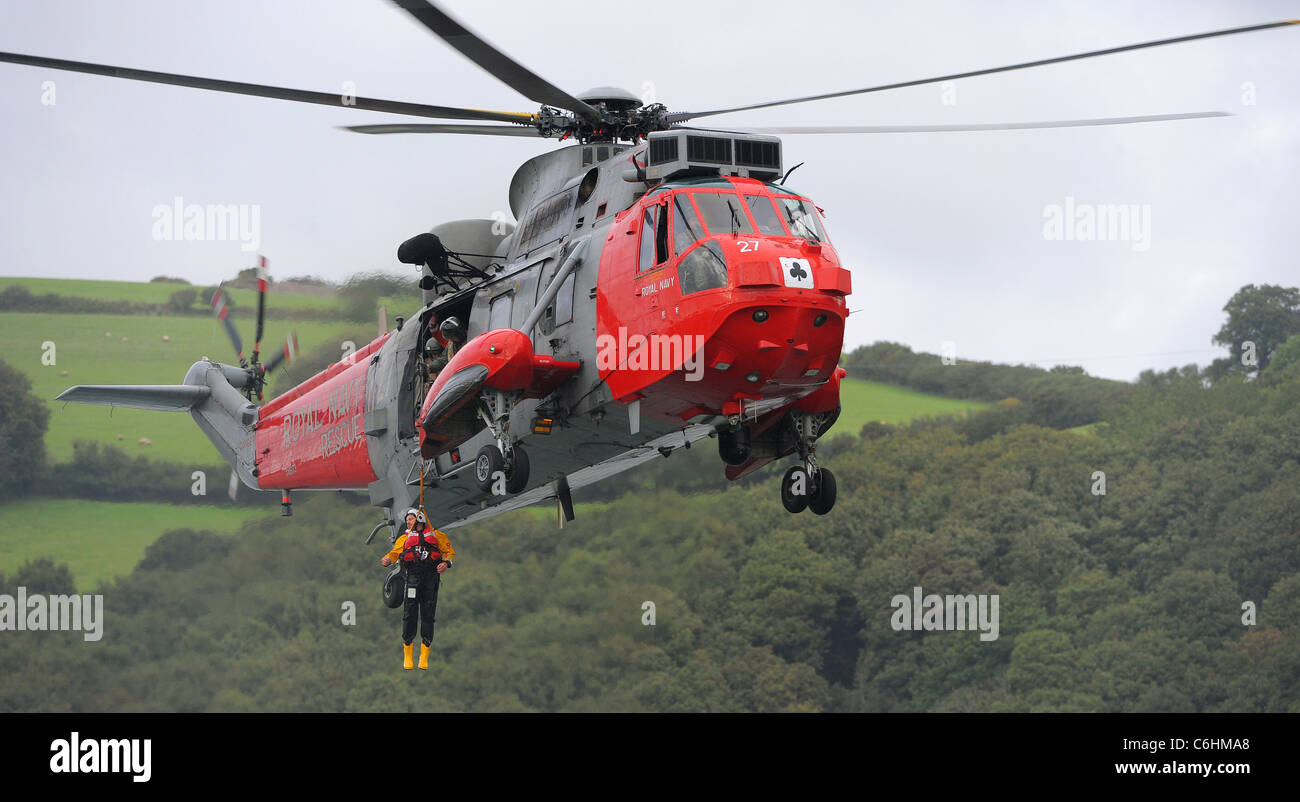 An RNLI lifeboatman is winched onto a Royal Navy Sea King helicopter ...
