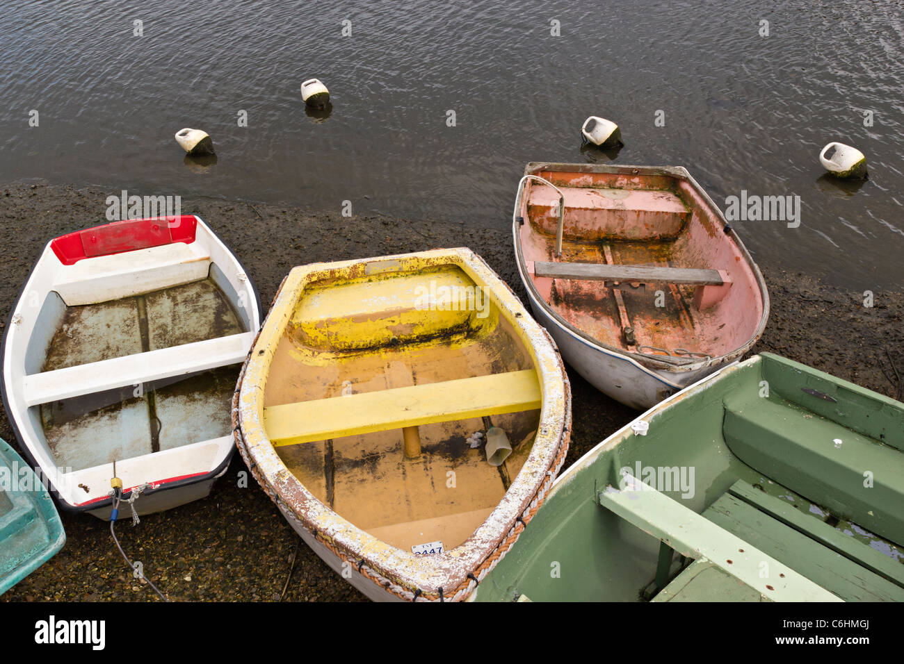 Empty colourful dinghies dinghy mooring tied up on river bank disused ...