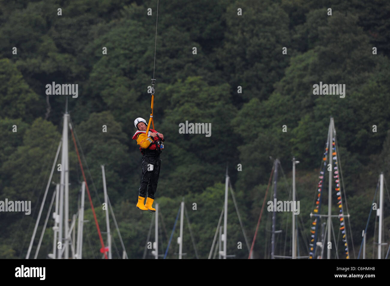 An RNLI lifeboatman is winched onto a Royal Navy Sea King helicopter ...