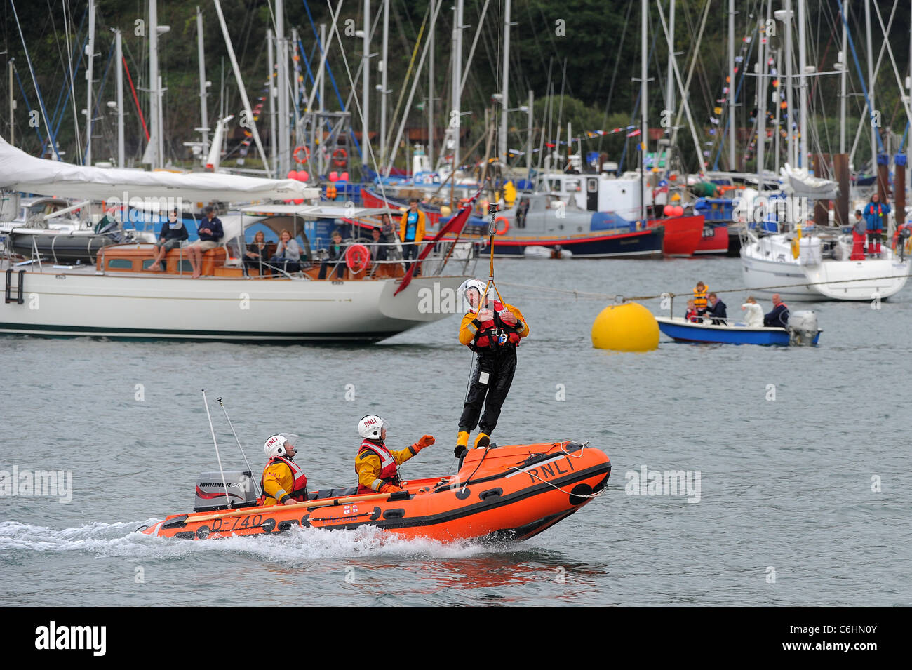 An RNLI Lifeboatman is winched back into an inshore lifeboat from a ...