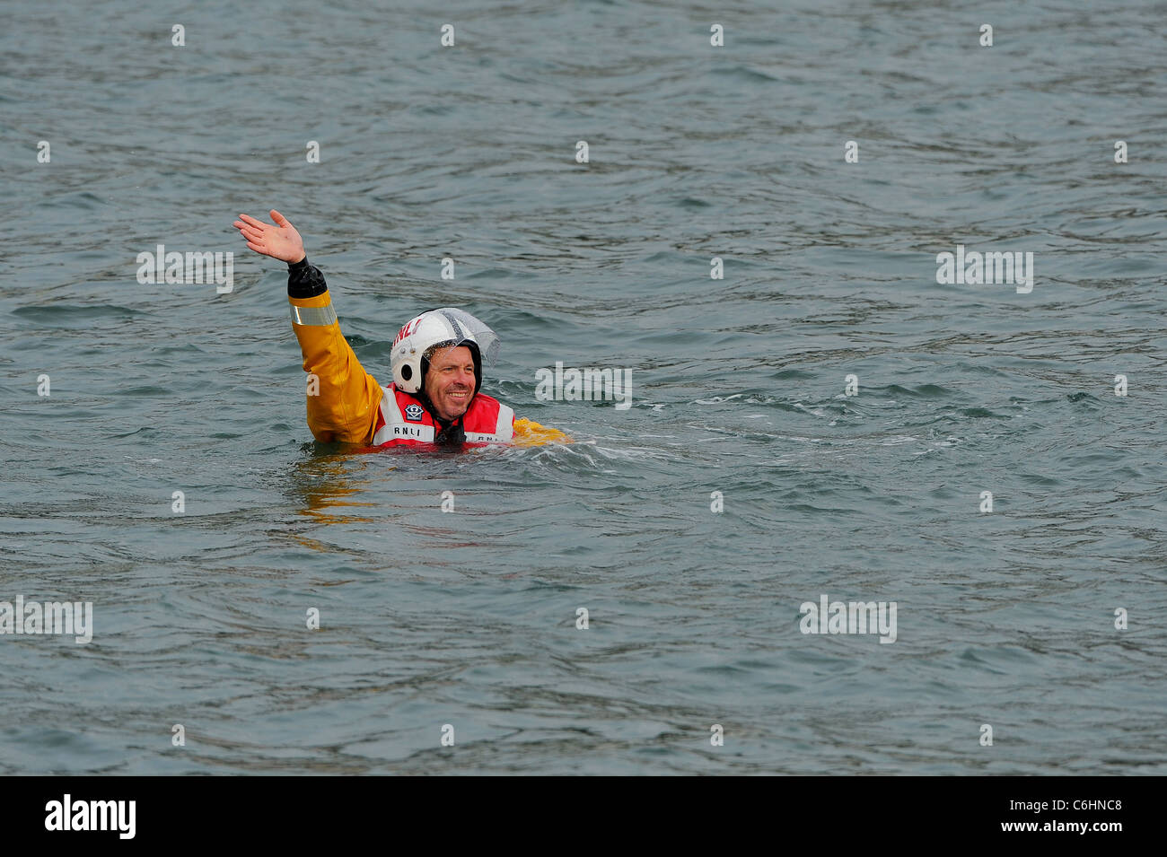 An RNLI Lifeboatman awaits rescue by a Royal Navy Sea King helicopter ...