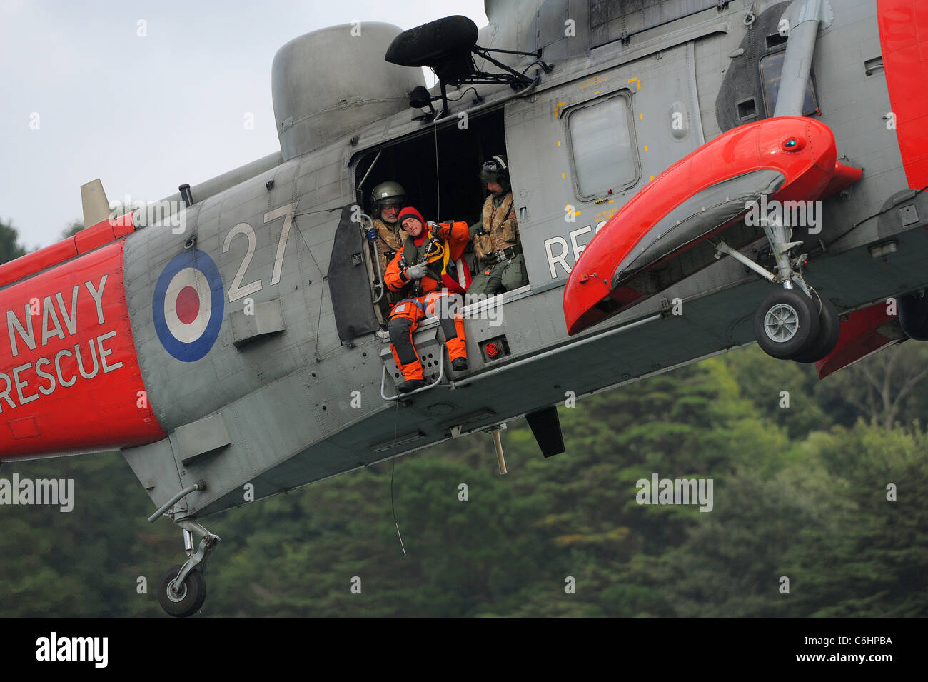 A Royal Navy rescue diver prepares to jump from a Sea King helicopter ...