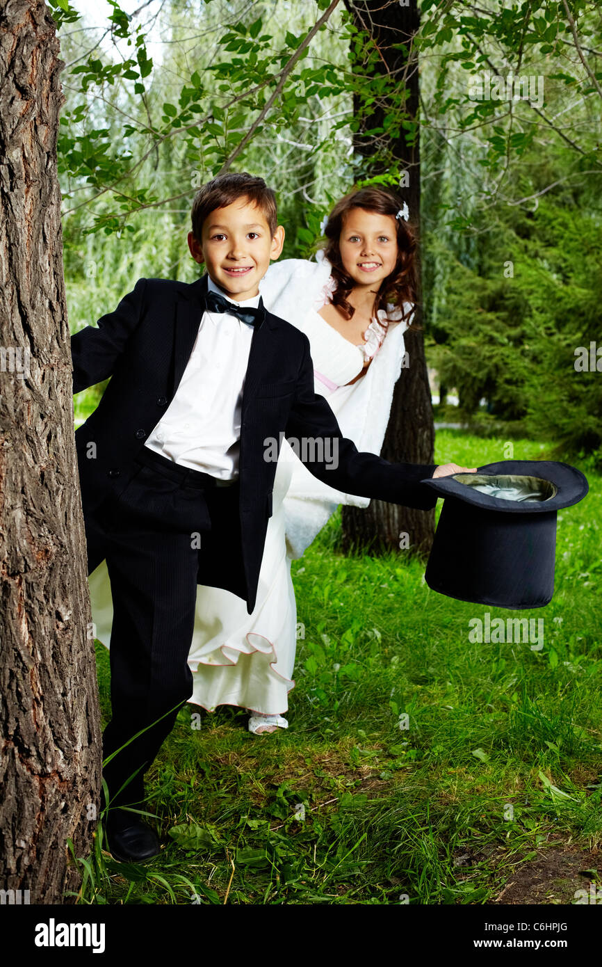 Portrait of cute boy groom and girl bride in the park Stock Photo - Alamy