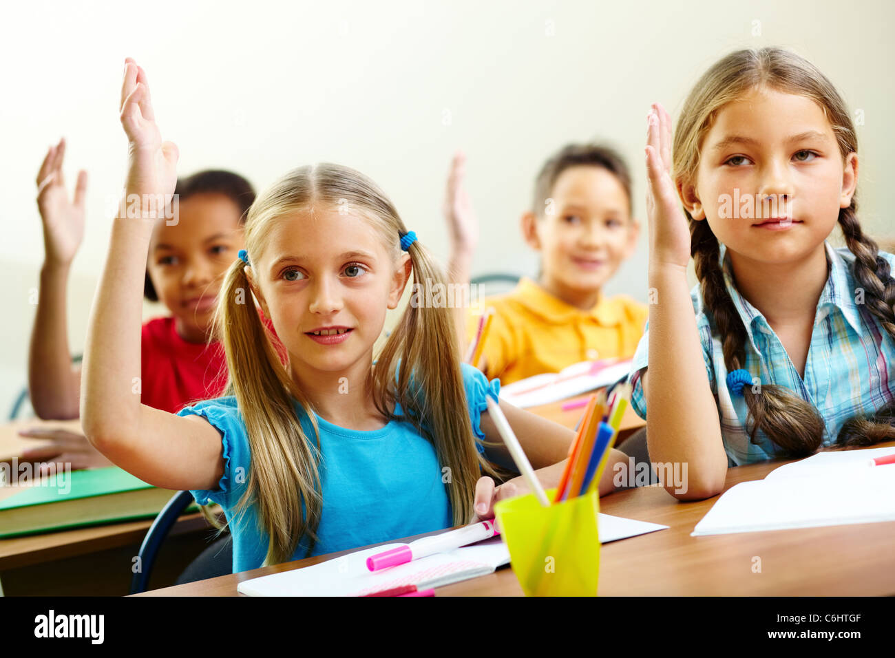 Image of pupils raising arms during the lesson Stock Photo - Alamy