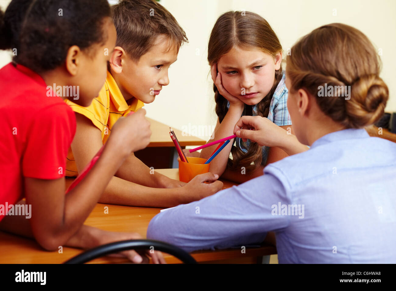 Portrait of smart schoolchildren and their teacher interacting in ...