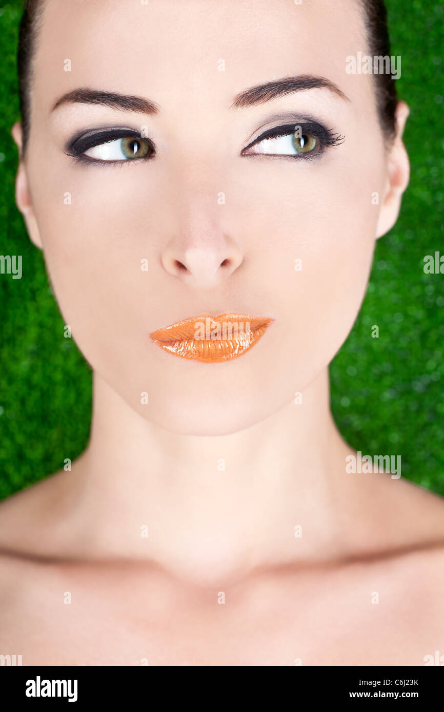 Closeup portrait of a beautiful suspicious woman looking away in studio ...