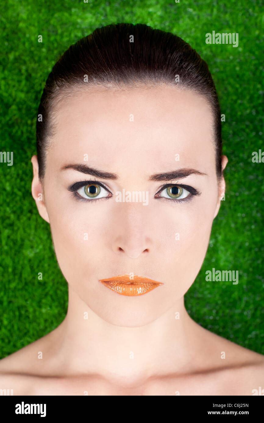 Closeup portrait of a serious angry beautiful woman with green eyes and ...