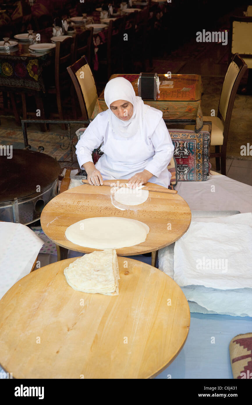 Turkey, Istanbul, Sultanahmet, woman rolling out bread dough in ...