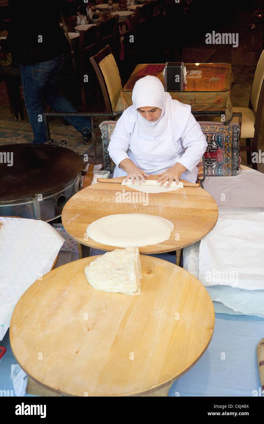 Turkey, Istanbul, Sultanahmet, woman rolling out bread dough in ...