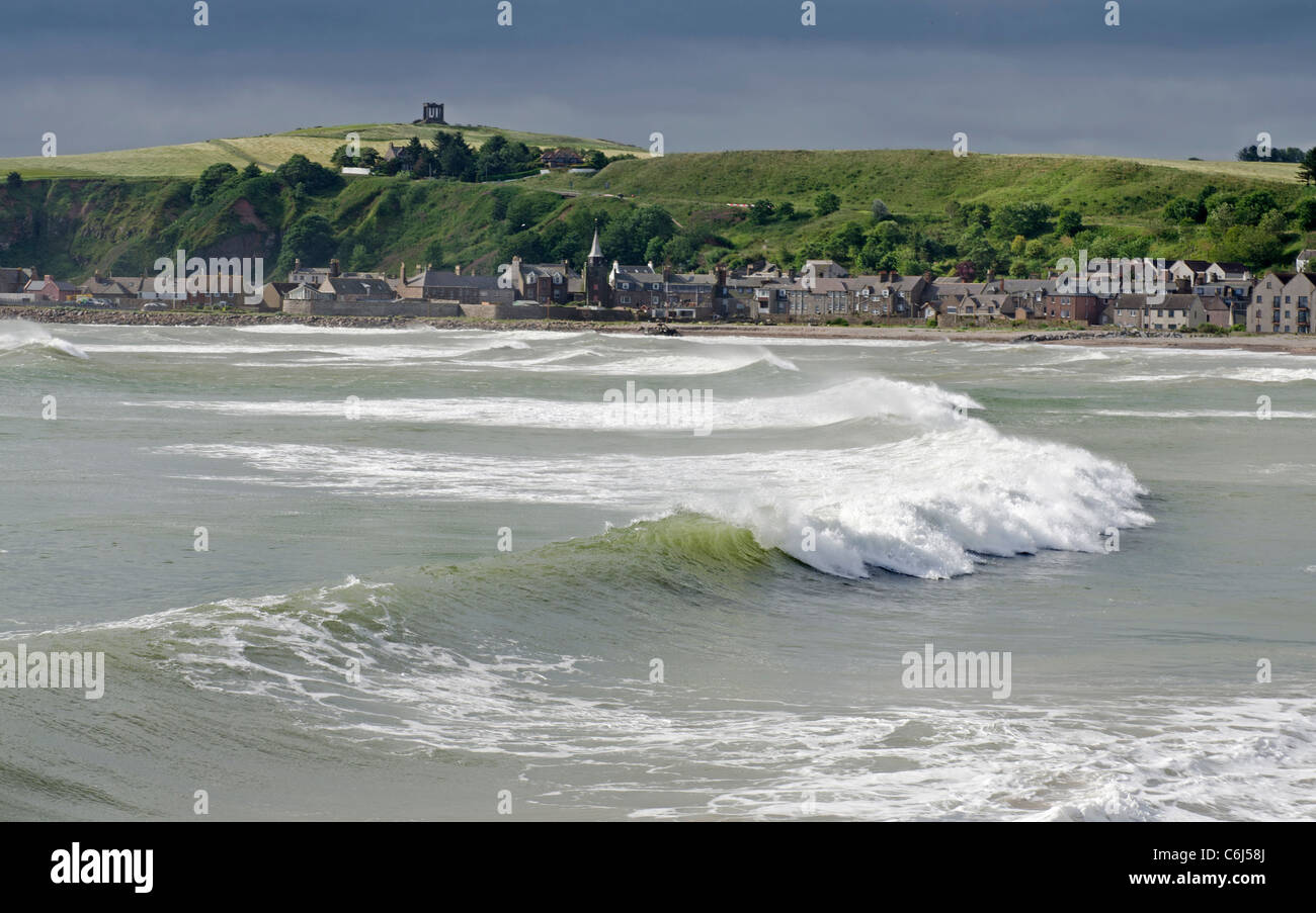Stonehaven Bay with surf breaking on shore and dark stormy sky ...