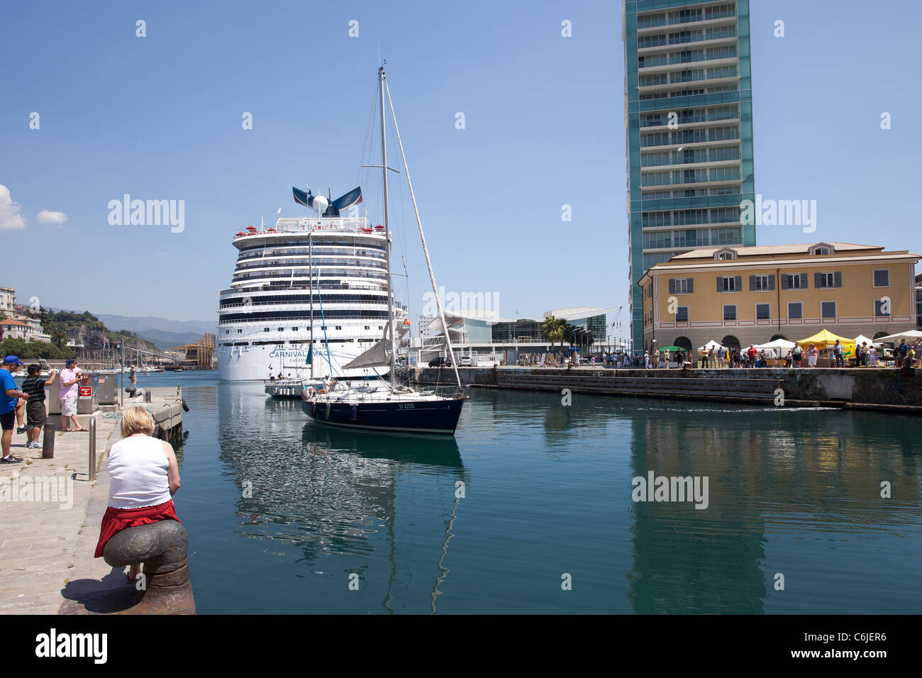 Sailboat in marina harbor sails past huge cruise ship. Cruise ship ...