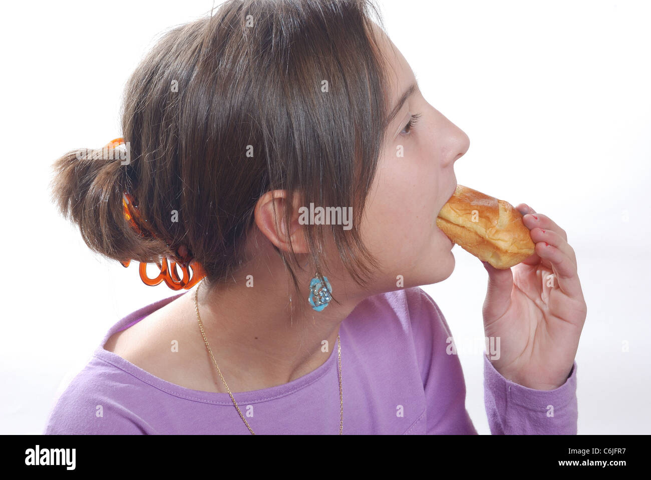 A young girl eating a bun Stock Photo - Alamy