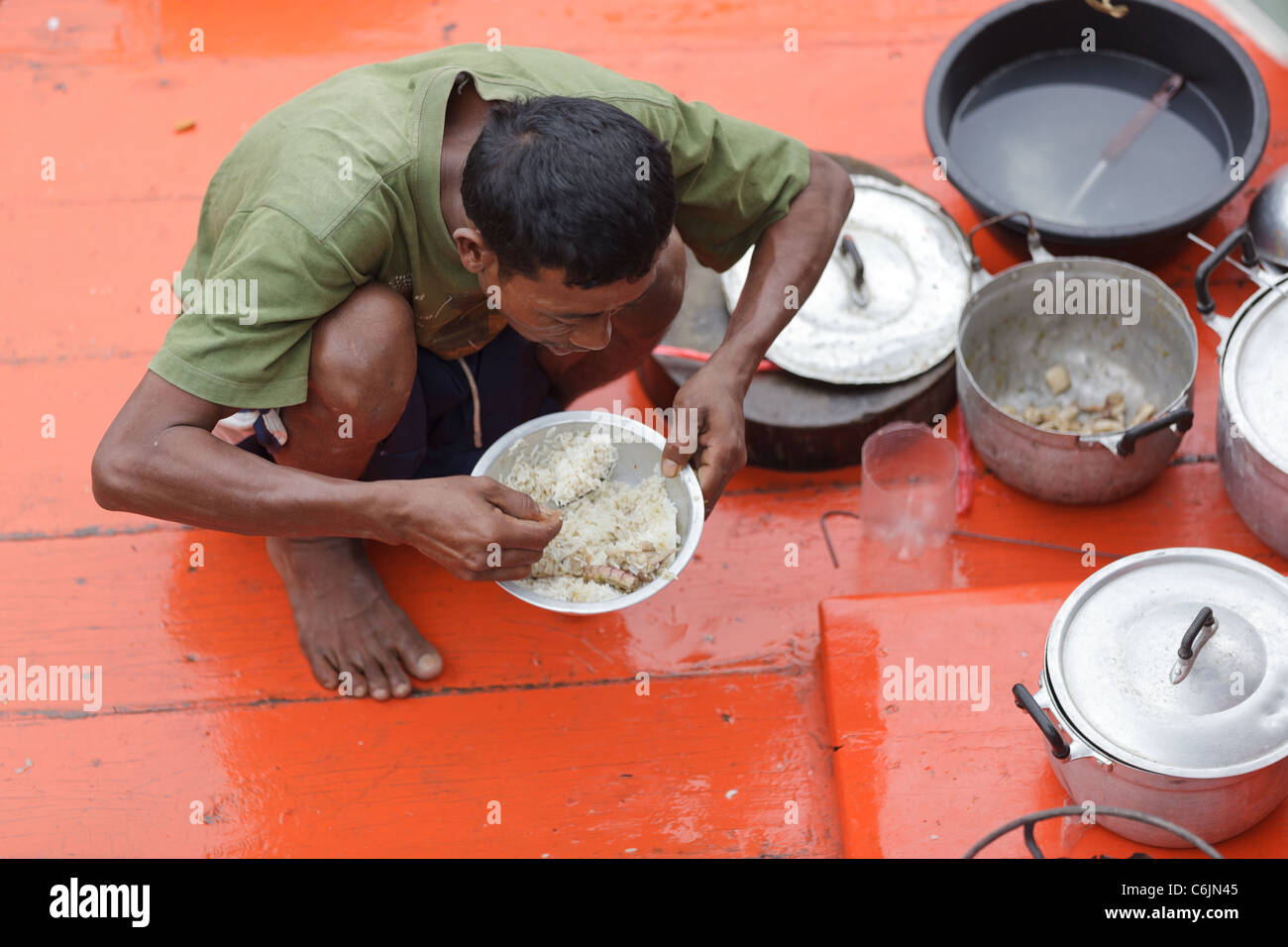 Burmese fisherman eating fish food on boat at Thetsaban Na Thon port ...