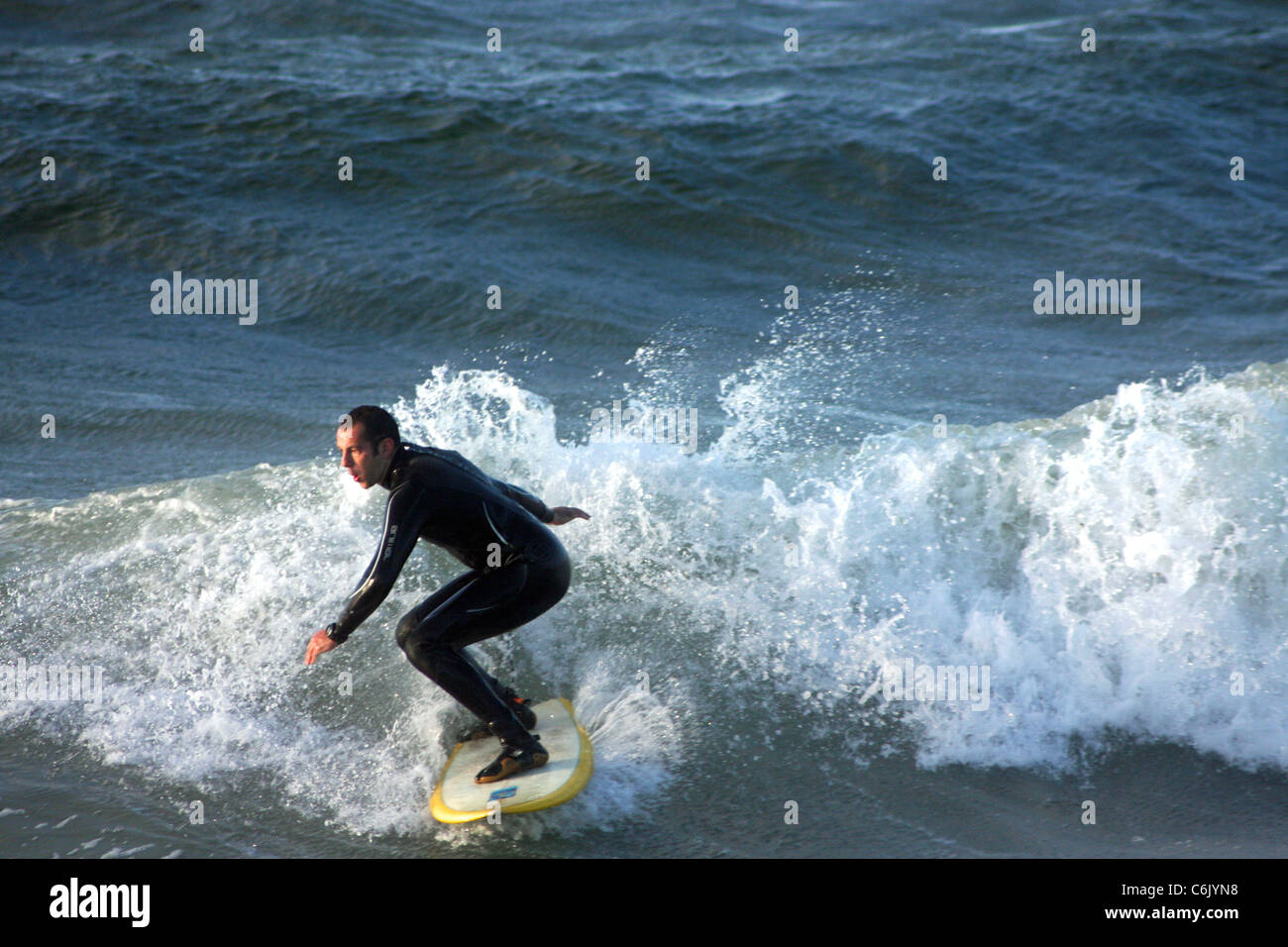 Surfer riding the waves off Peel, IOM UK Stock Photo - Alamy
