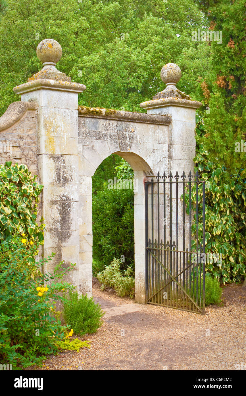A nice gate in a stone wall in an english garden Stock Photo - Alamy