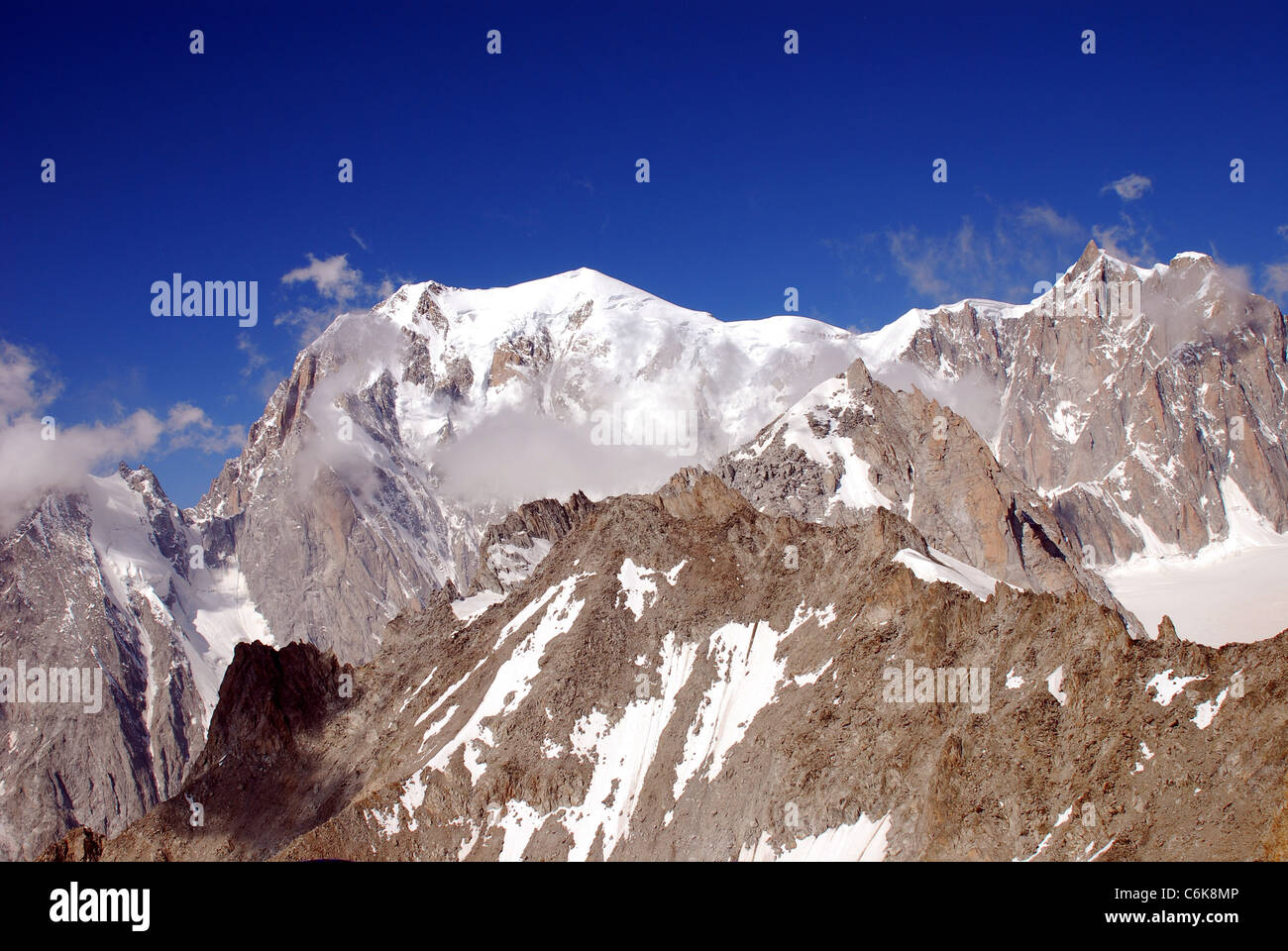 the snow capped summit of Mont Blanc rises above the surrounding ...