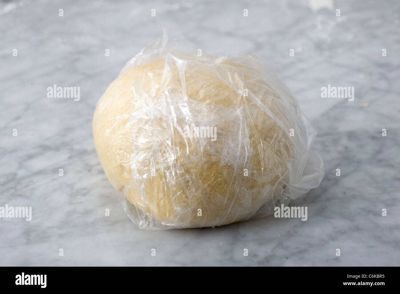 Fresh ball of dough wrapped in cellophane Stock Photo - Alamy