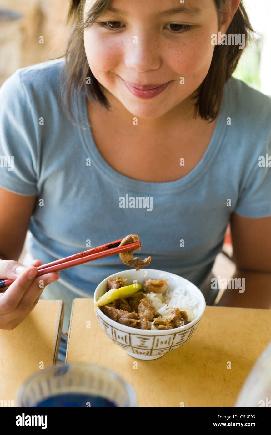 Girl eating food using chopsticks Stock Photo - Alamy