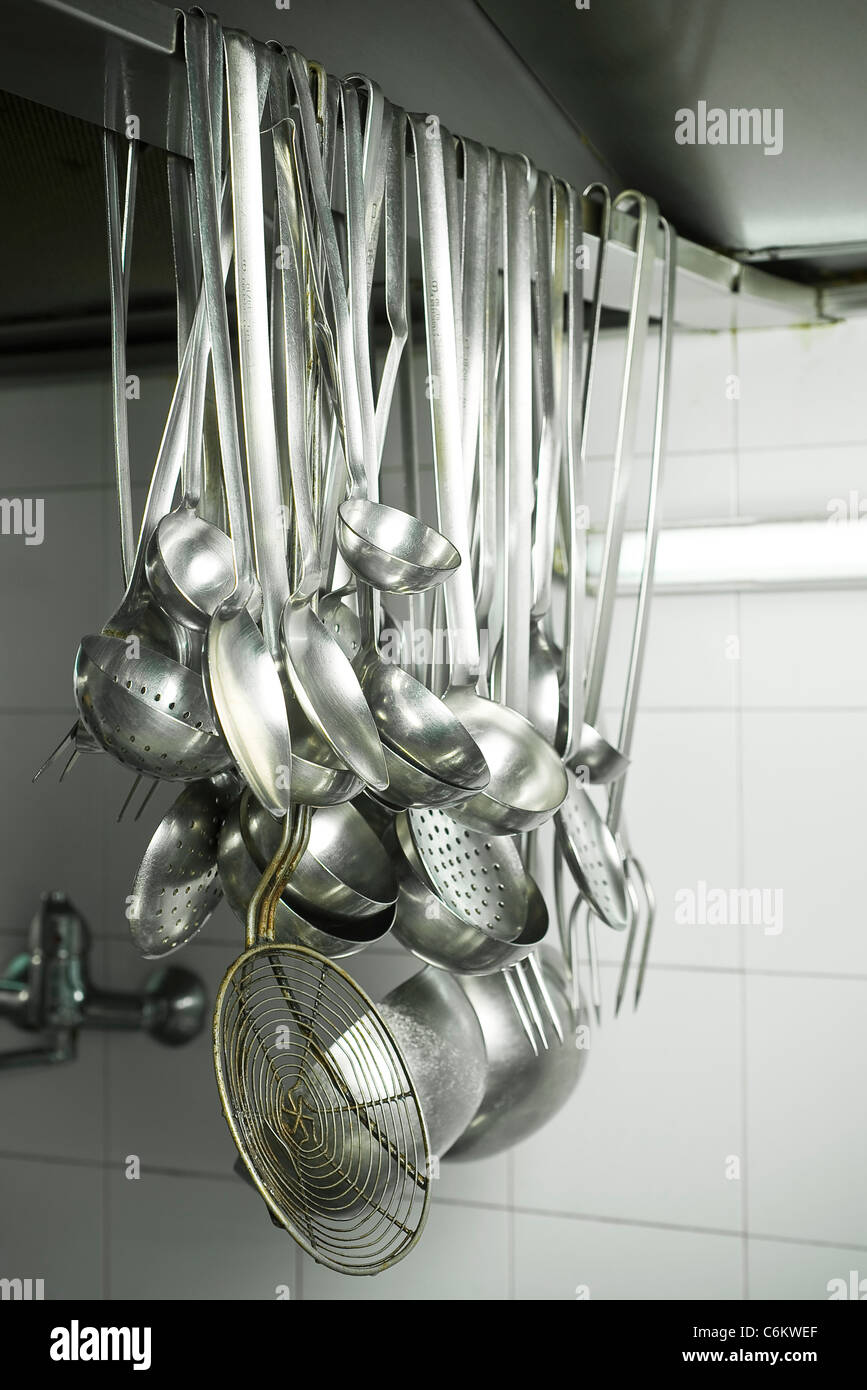 Cooking utensils hanging in kitchen Stock Photo - Alamy