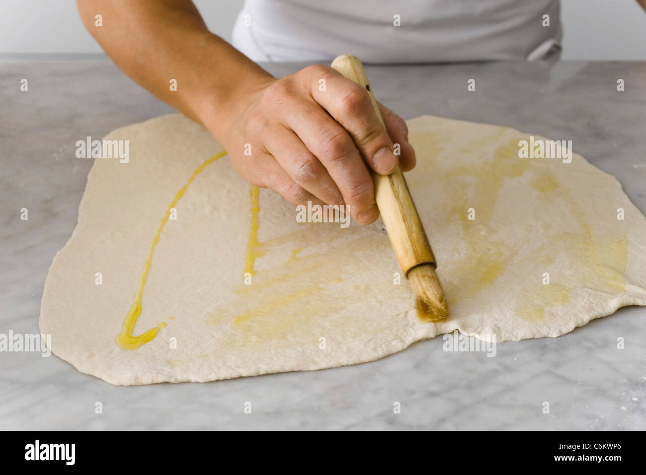 Brushing dough with olive oil Stock Photo - Alamy