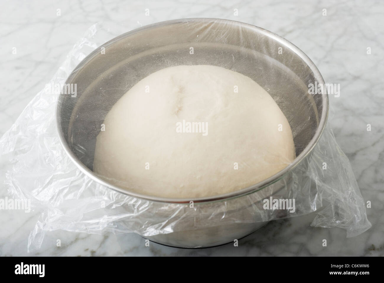 Basic bread dough rising in covered bowl Stock Photo - Alamy