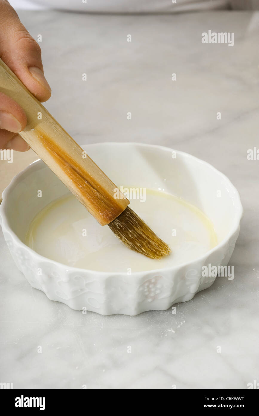 Greasing baking dish with pastry brush Stock Photo - Alamy