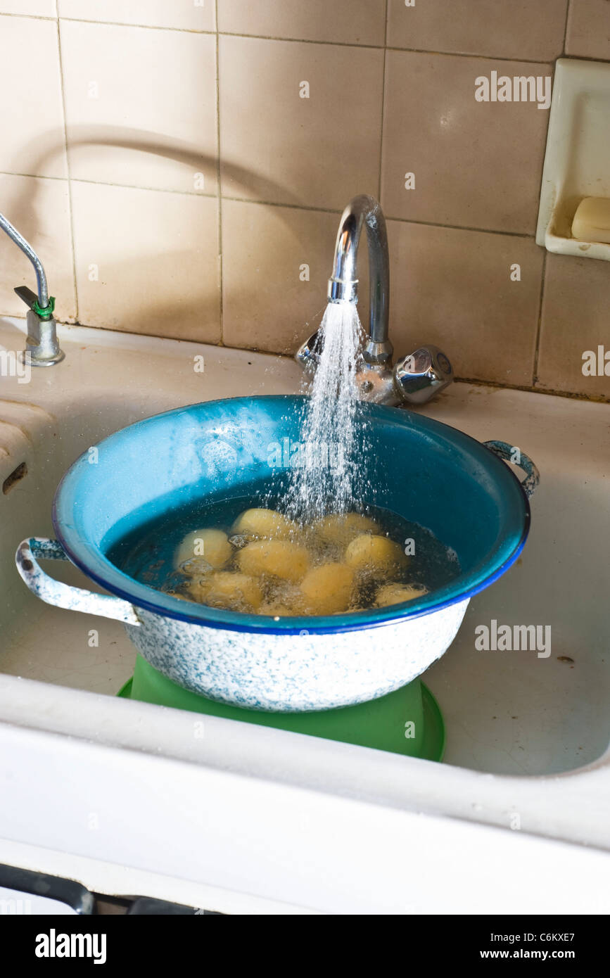 Washing potatoes in kitchen sink Stock Photo - Alamy