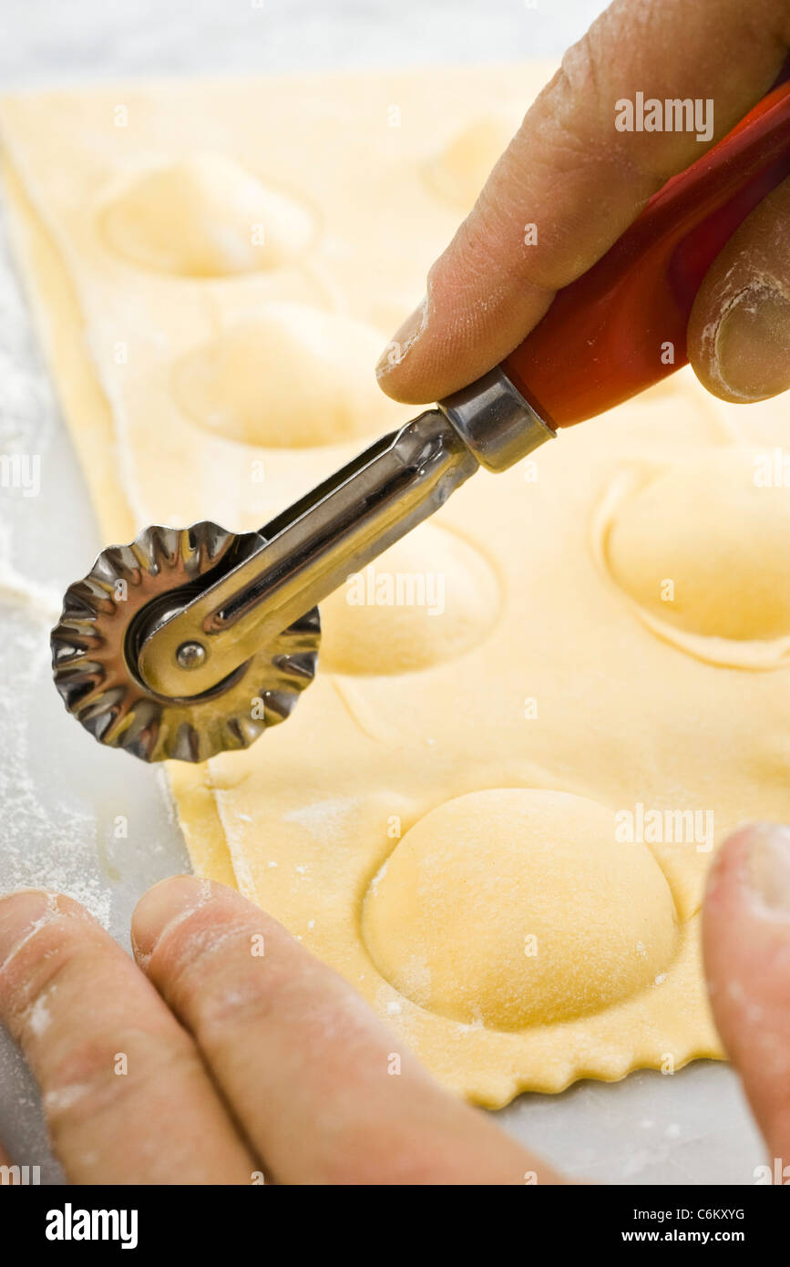 Cutting fresh ricotta ravioli with pastry wheel Stock Photo - Alamy
