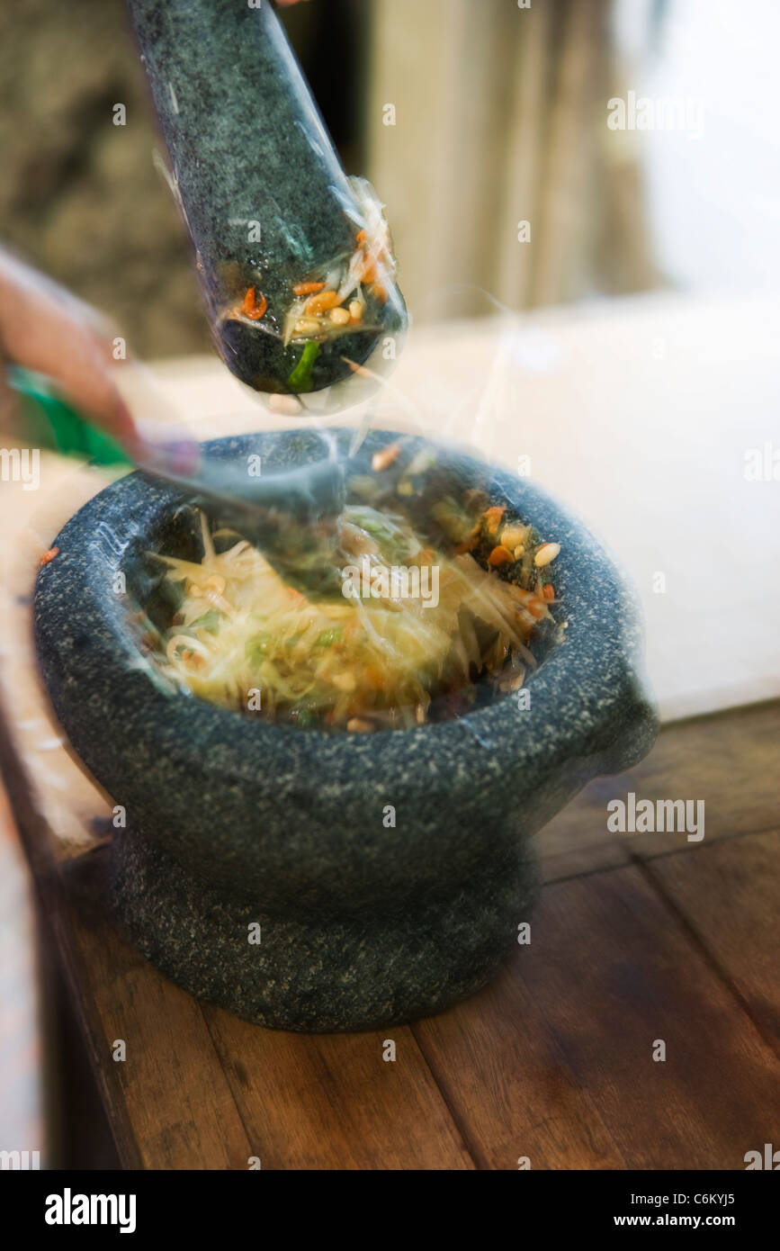 Grinding ingredients with mortar and pestle Stock Photo - Alamy