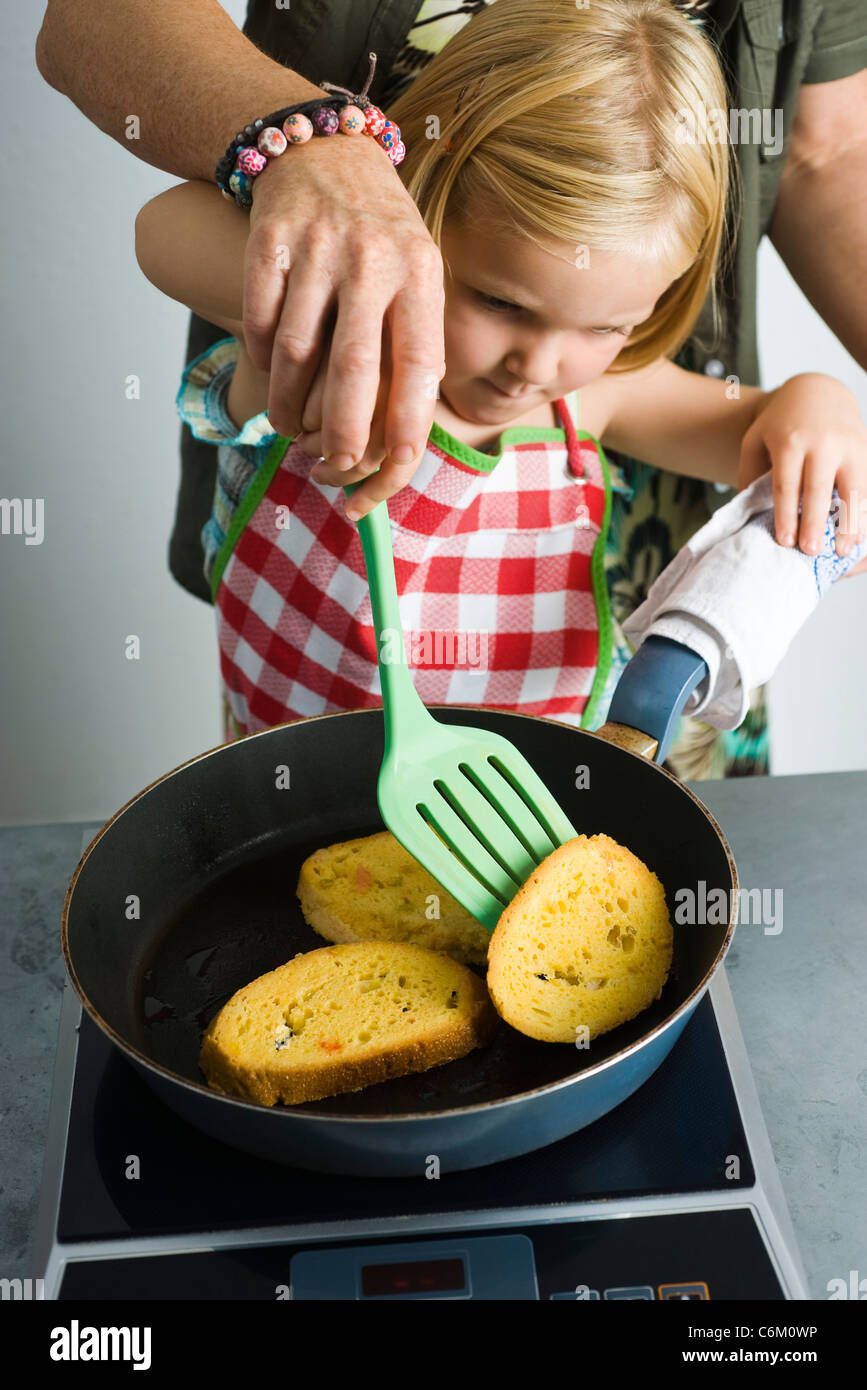 Little girl preparing food with adult Stock Photo - Alamy