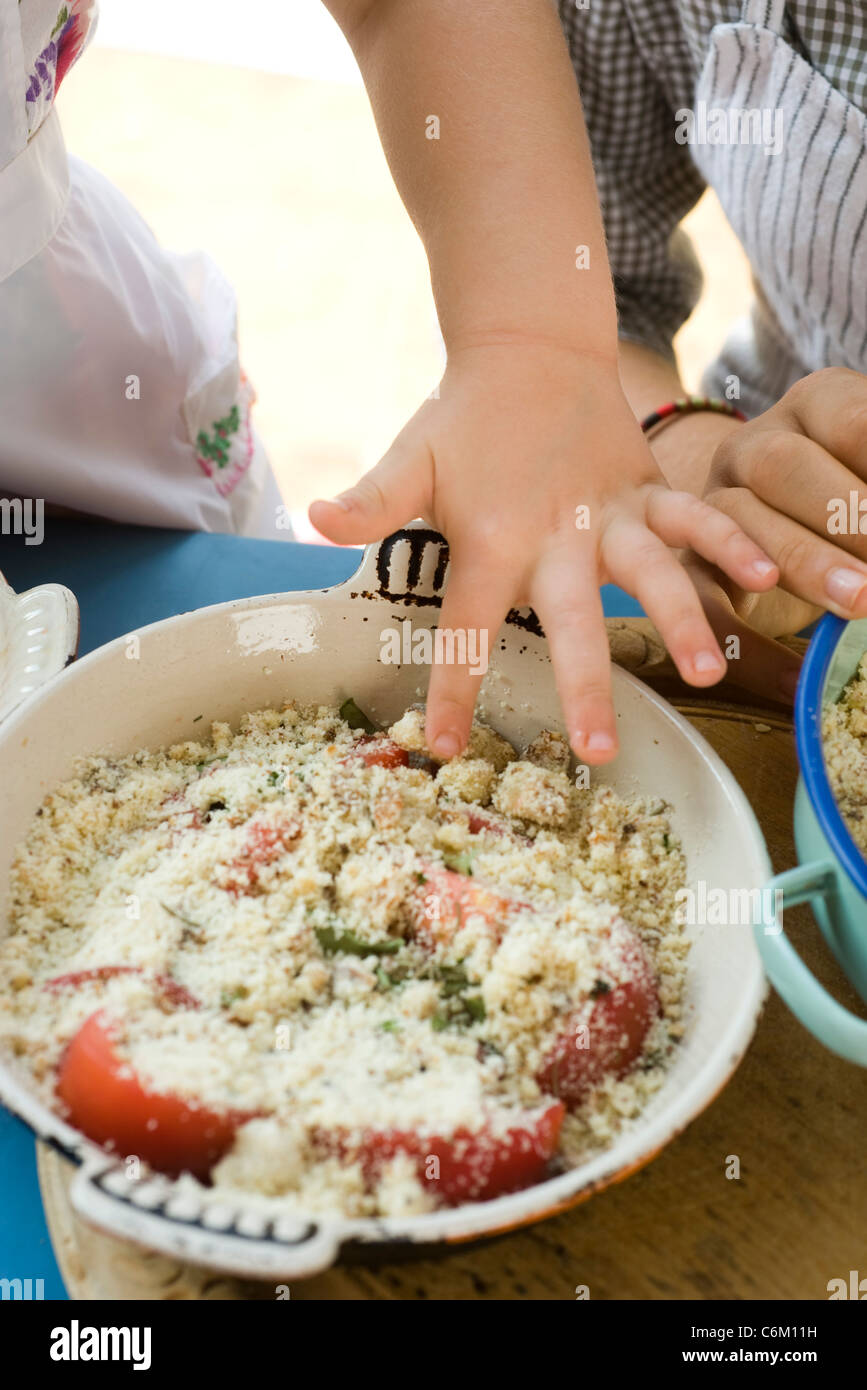 Child tasting ingredients in casserole dish, cropped Stock Photo - Alamy