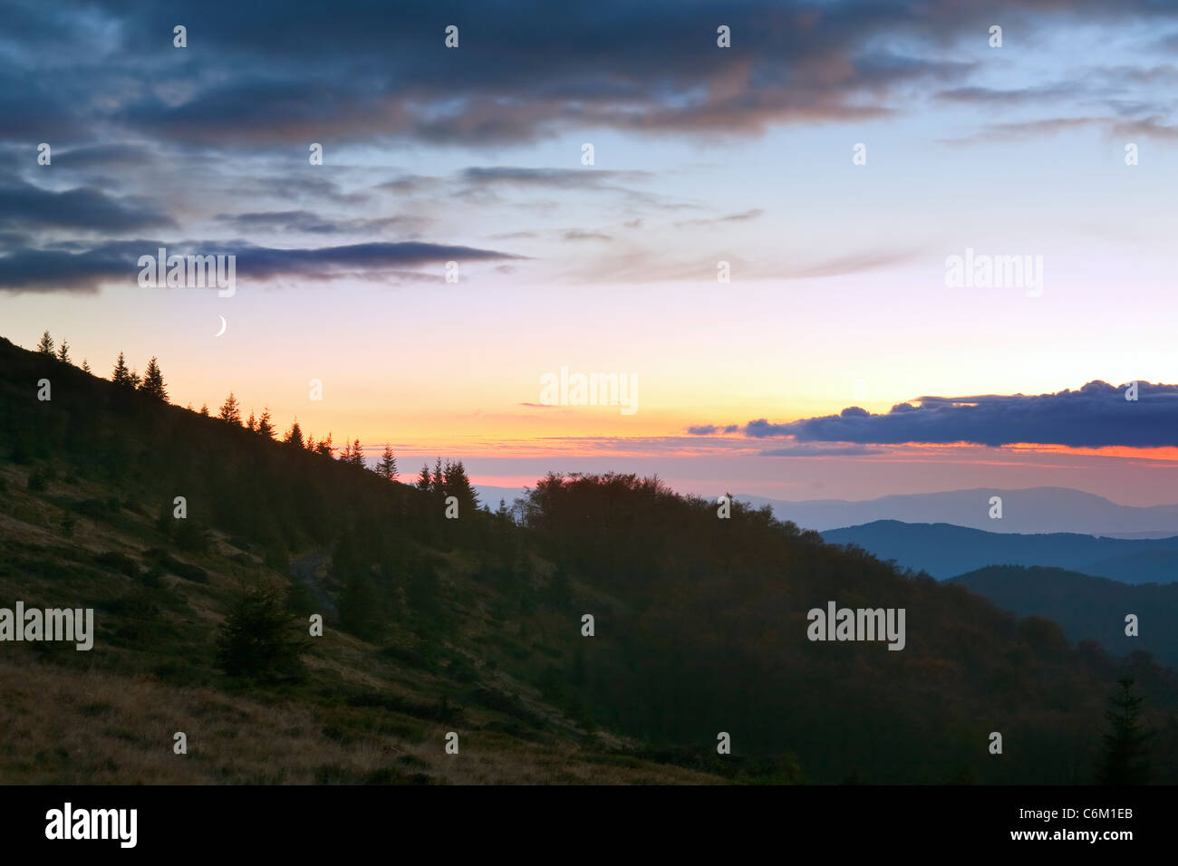 Autumn mountain sunset and moon in evening glow sky Stock Photo - Alamy