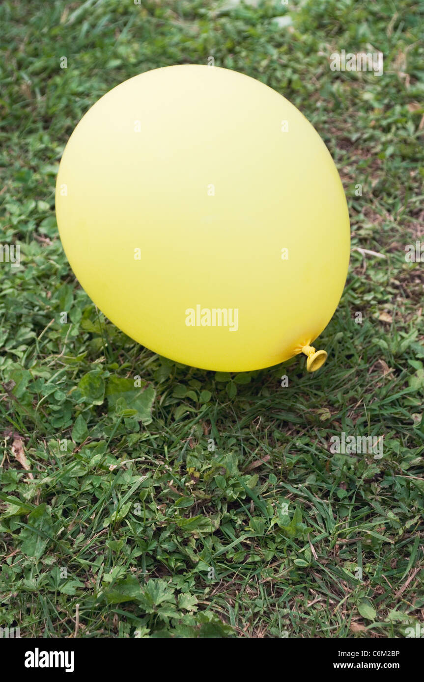 inflated yellow balloon on grass Stock Photo - Alamy