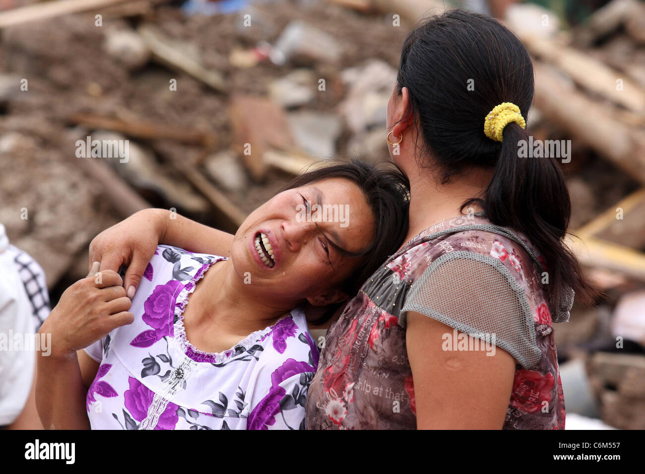 Women cry for their family members following a mudslide occured ...