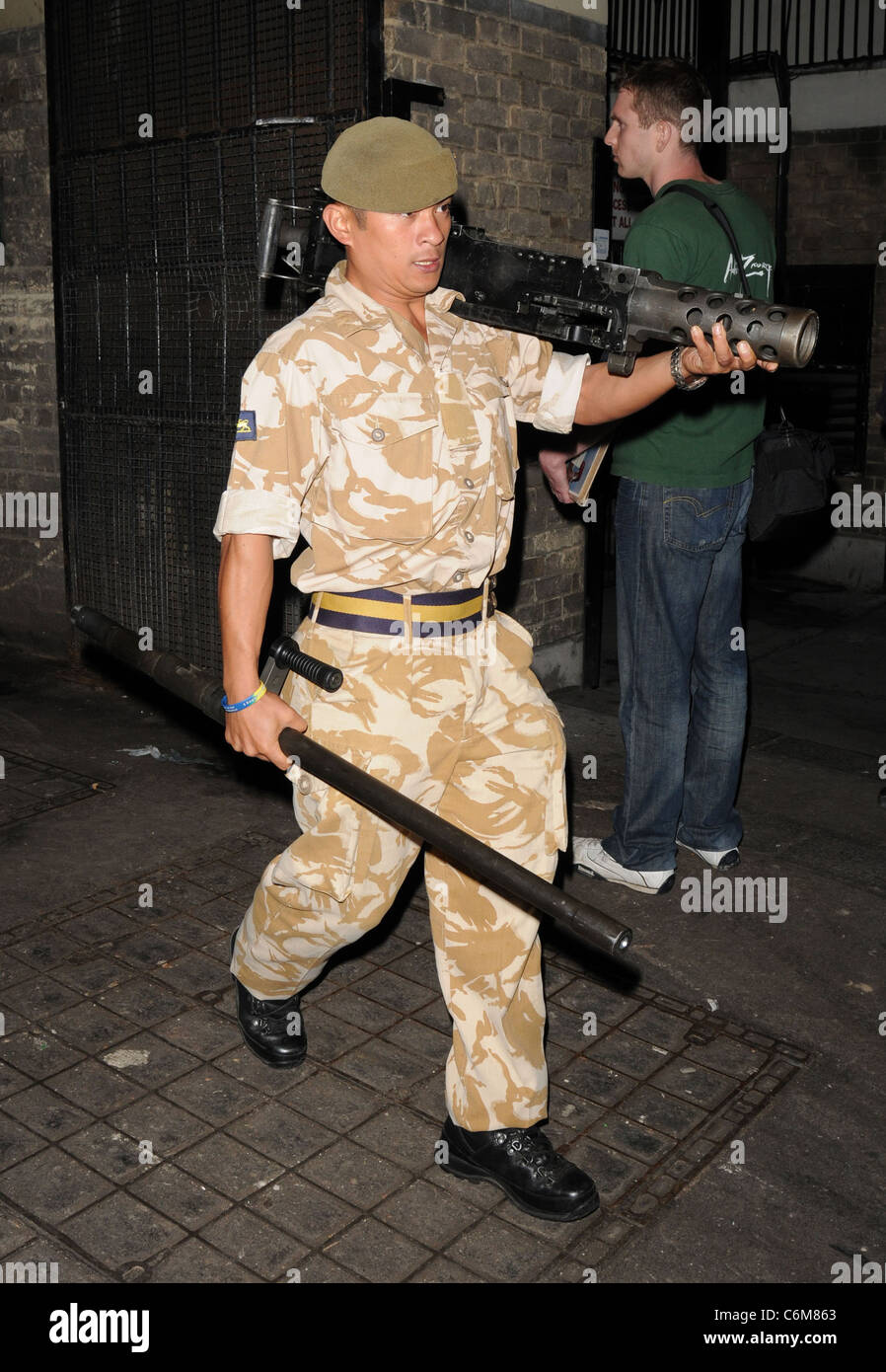 An Army Serviceman carries a very large automatic machine gun which was ...