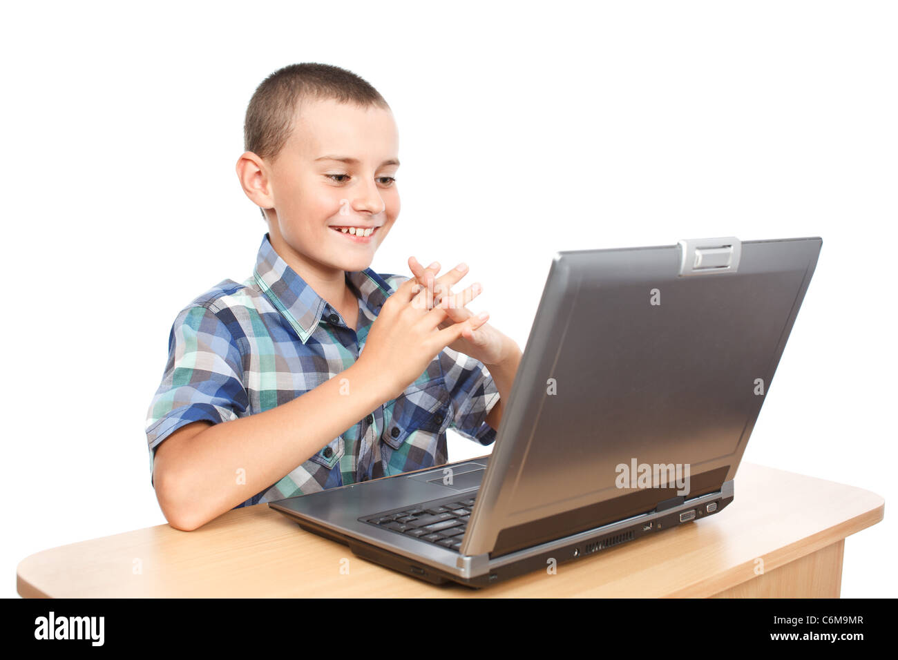 Portrait of a cheerful boy at his laptop, isolated on white background ...