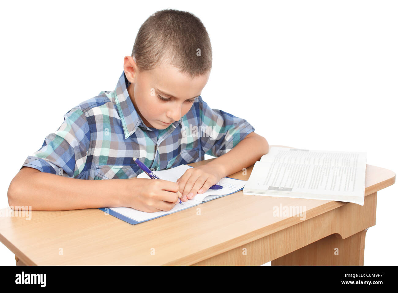 Portrait of a school boy doing homework at his desk, isolated on white ...