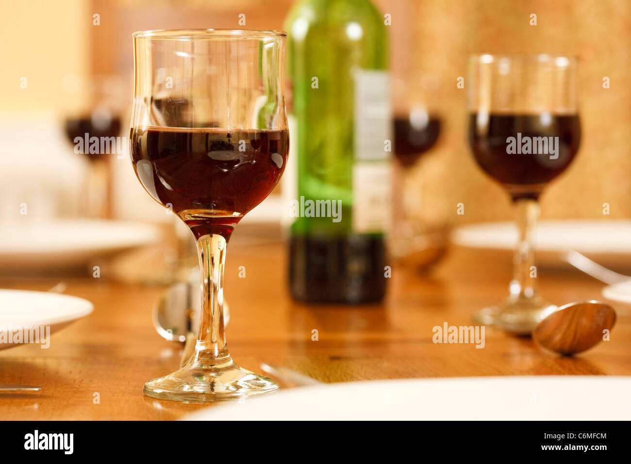 Dining table with a wine bottle and glasses filled with red wine Stock ...
