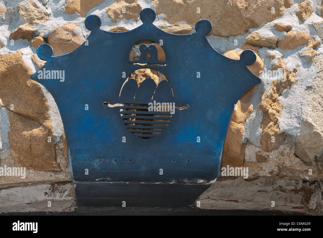 A large blue metal crown crest with small figures representing the ...