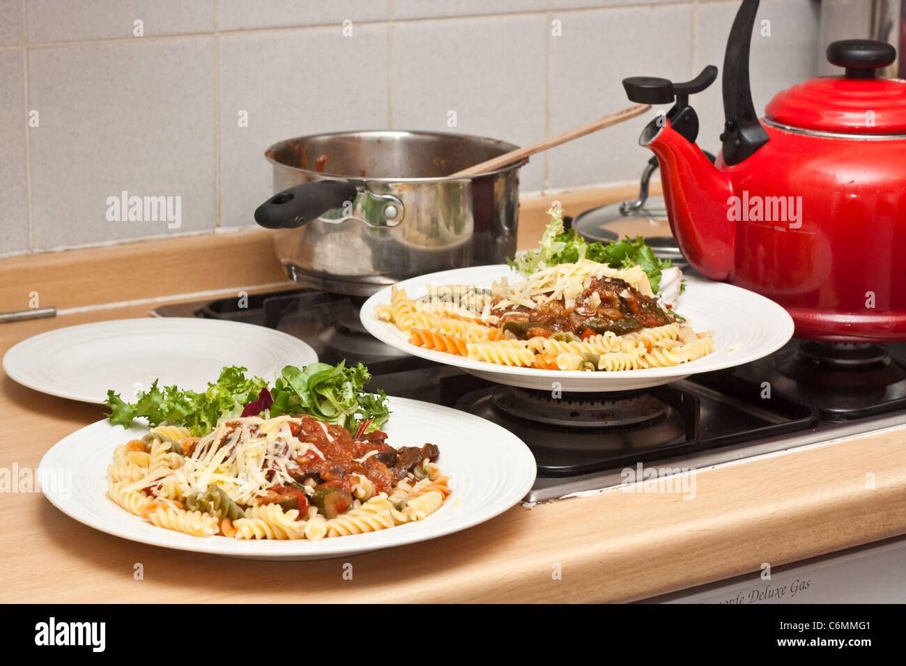 Everyday image of plates of freshly prepared food on a gas hob in a ...