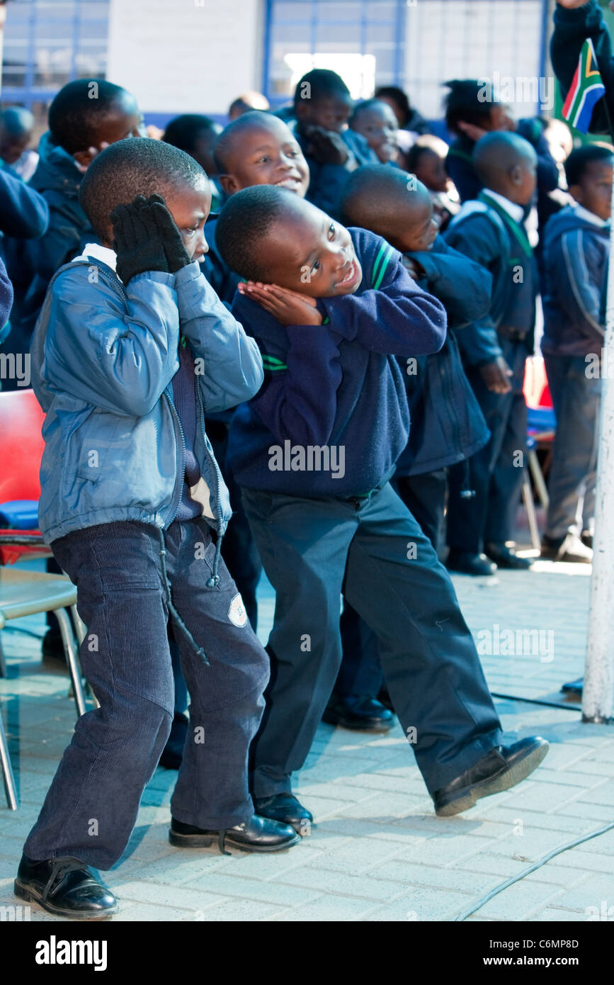 Primary school children assembled together at a rural school dancing ...