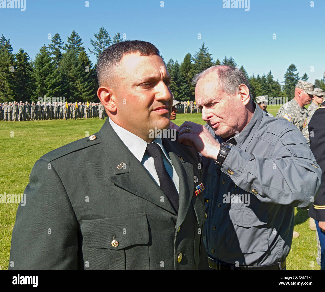 Family member pins lieutenant's bars on cadet during commissioning ...